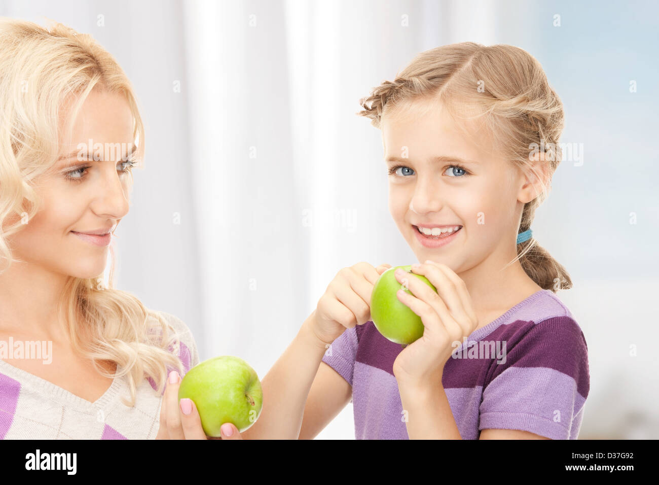 mother and little girl with green apple Stock Photo - Alamy