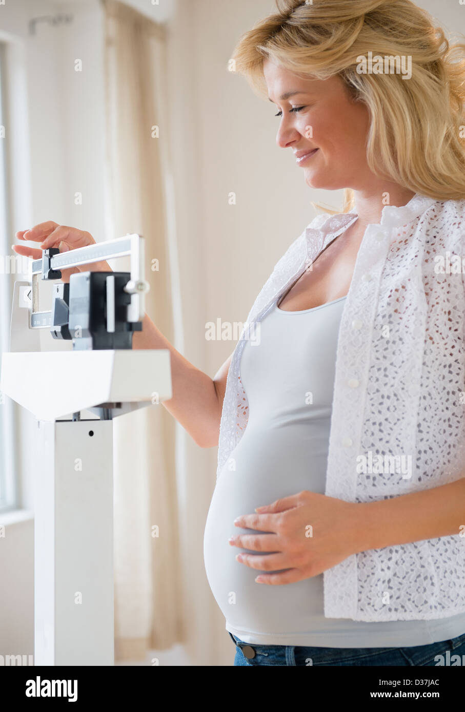 Pregnant woman on weighting scales Stock Photo - Alamy