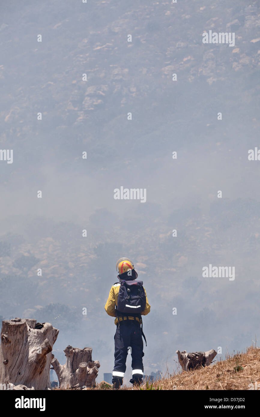 A fire fighter looks out after extinguishing a veld fire in Hout Bay ...