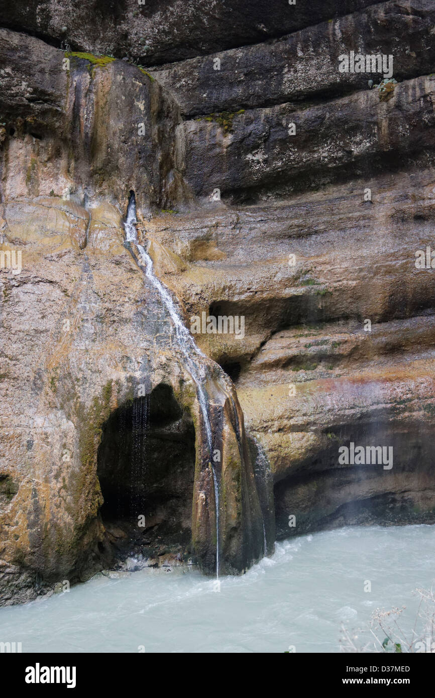 Mountain cave under falls Stock Photo - Alamy