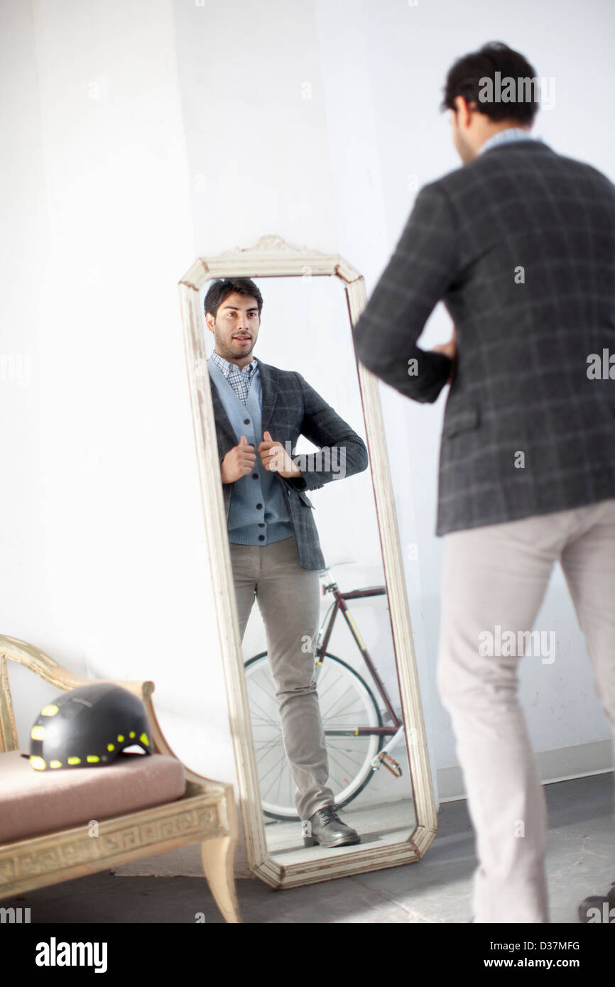 Man examining himself in mirror Stock Photo - Alamy