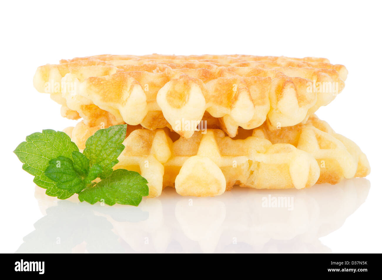 Pile of sweet waffles with green mint leaves isolated on white ...