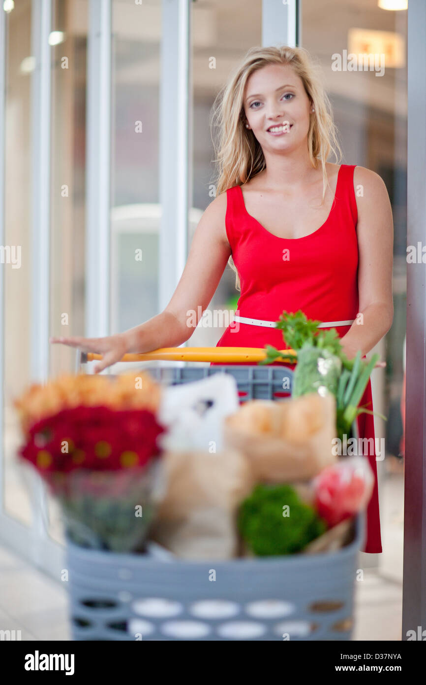 Woman pushing shopping cart Stock Photo - Alamy