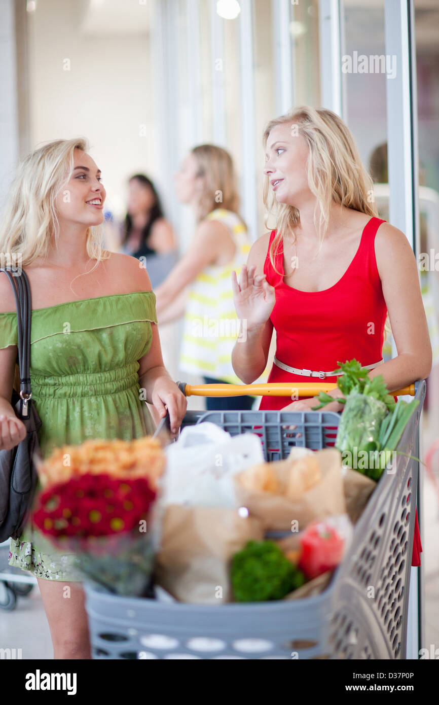 Women pushing shopping cart Stock Photo - Alamy