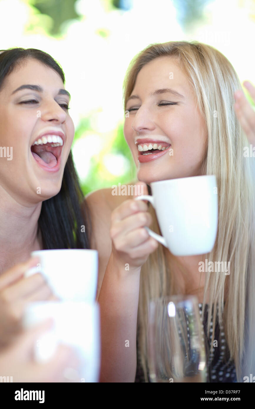 Women laughing and drinking coffee Stock Photo - Alamy