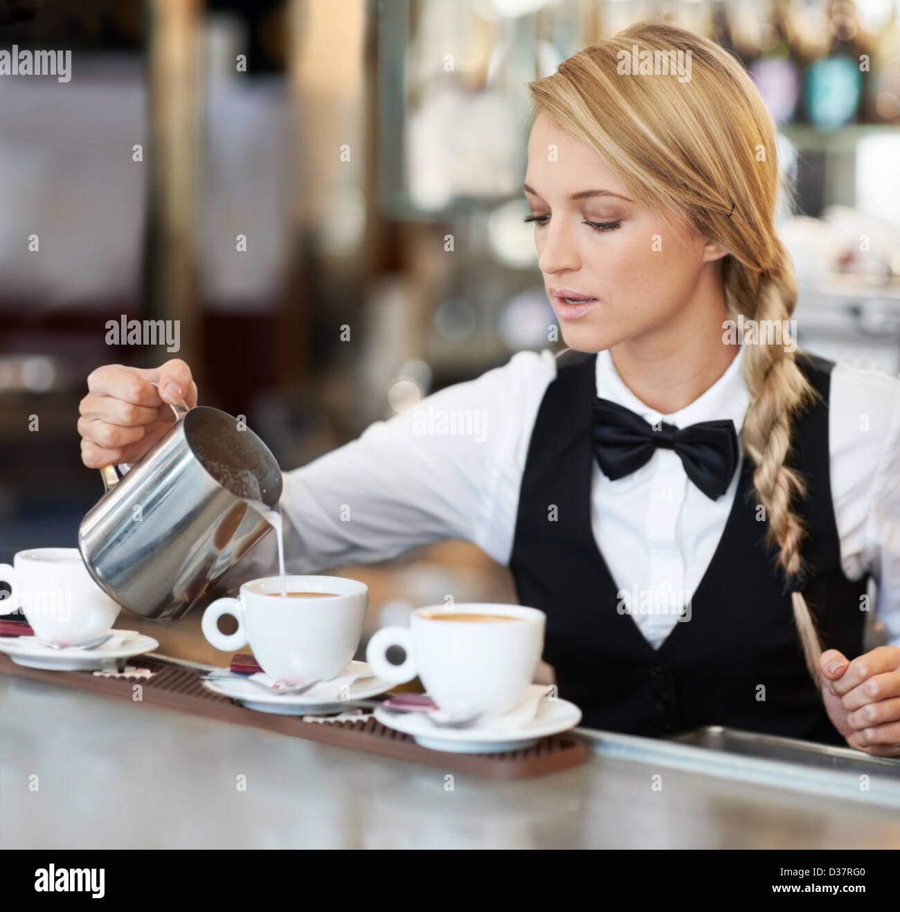 Denmark, Aarhus, Female barista pouring milk into coffee cup Stock ...