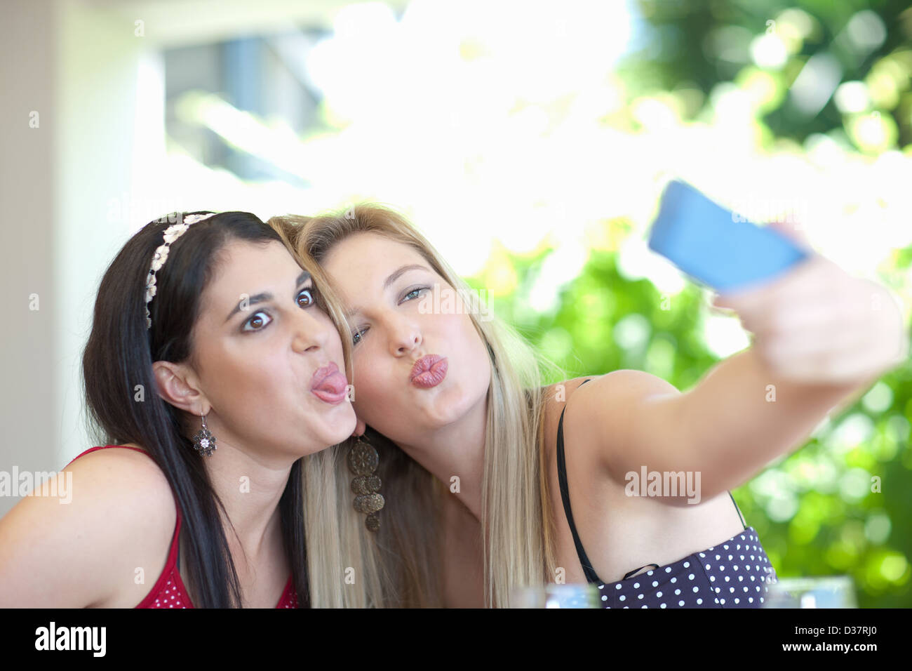 Smiling women taking pictures together Stock Photo - Alamy