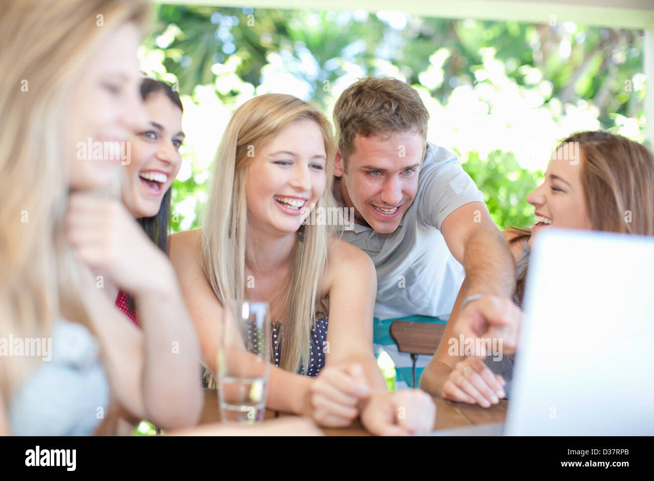 Friends using laptop together Stock Photo - Alamy