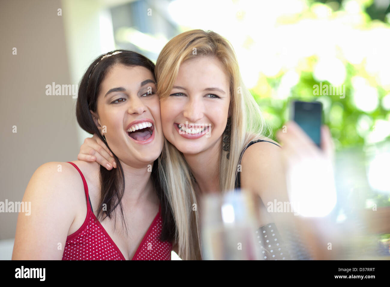 Smiling women taking pictures together Stock Photo - Alamy