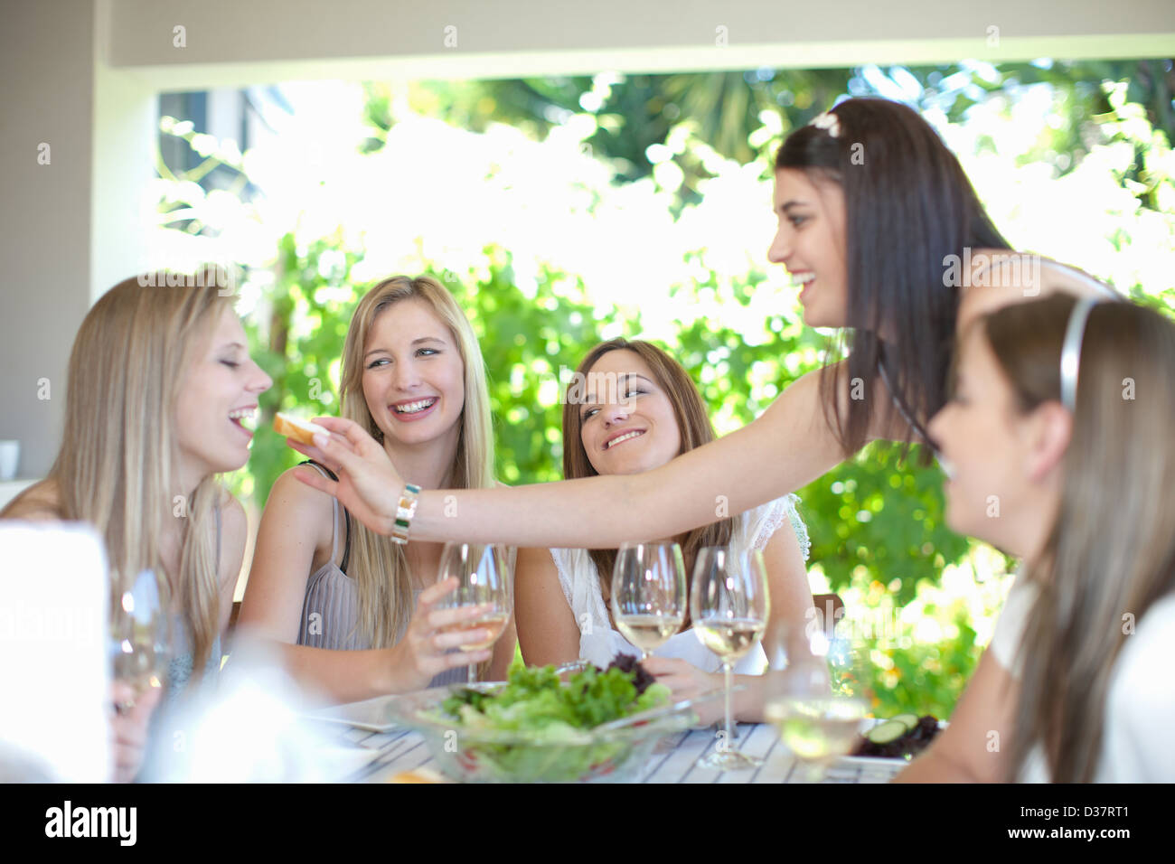 Woman feeding friend at table Stock Photo - Alamy