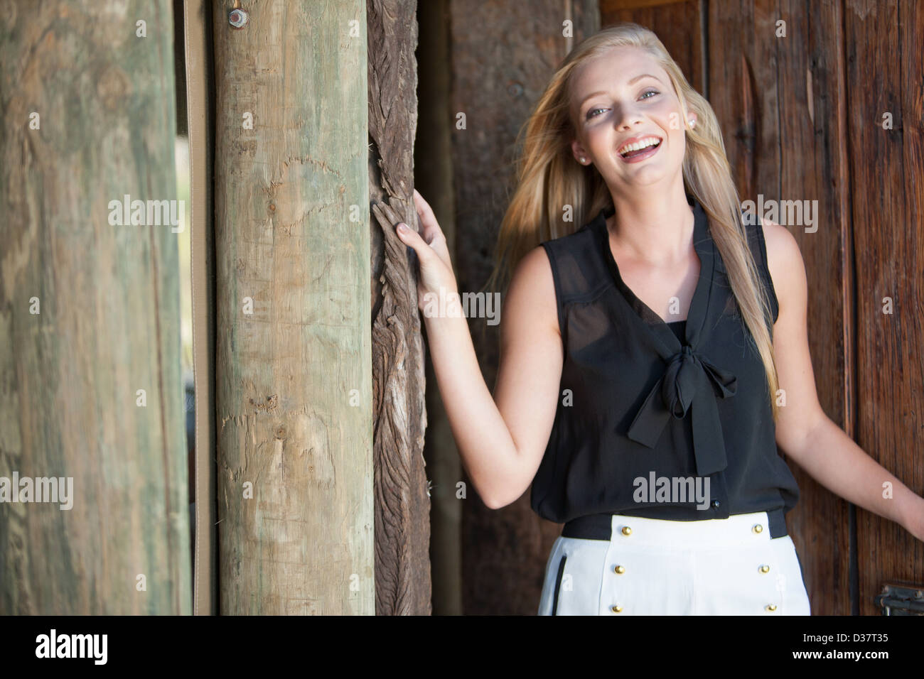 Smiling woman opening door Stock Photo - Alamy