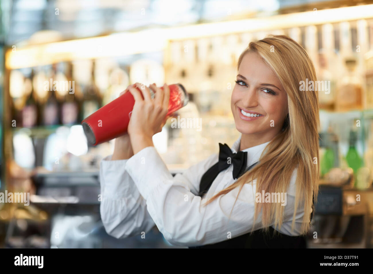 Denmark, Aarhus, Young female bartender using cocktail shaker Stock ...