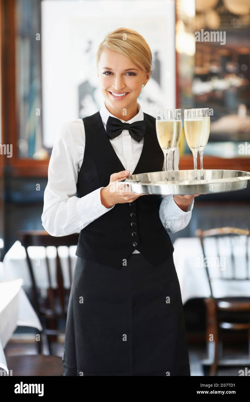 Denmark, Aarhus, Portrait of waitress holding champagne flutes on tray ...