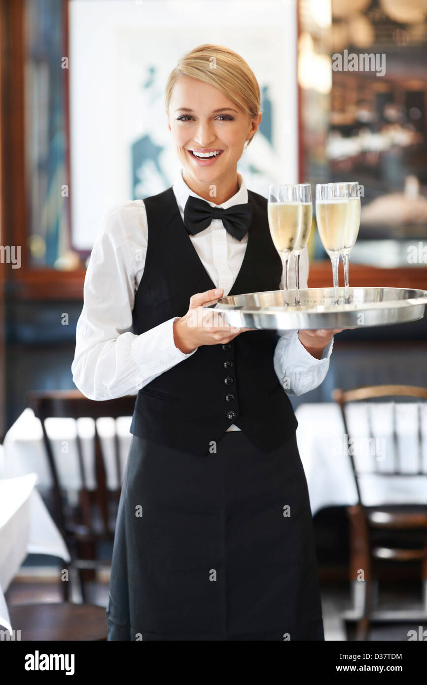 Denmark, Aarhus, Portrait of waitress holding champagne flutes on tray ...