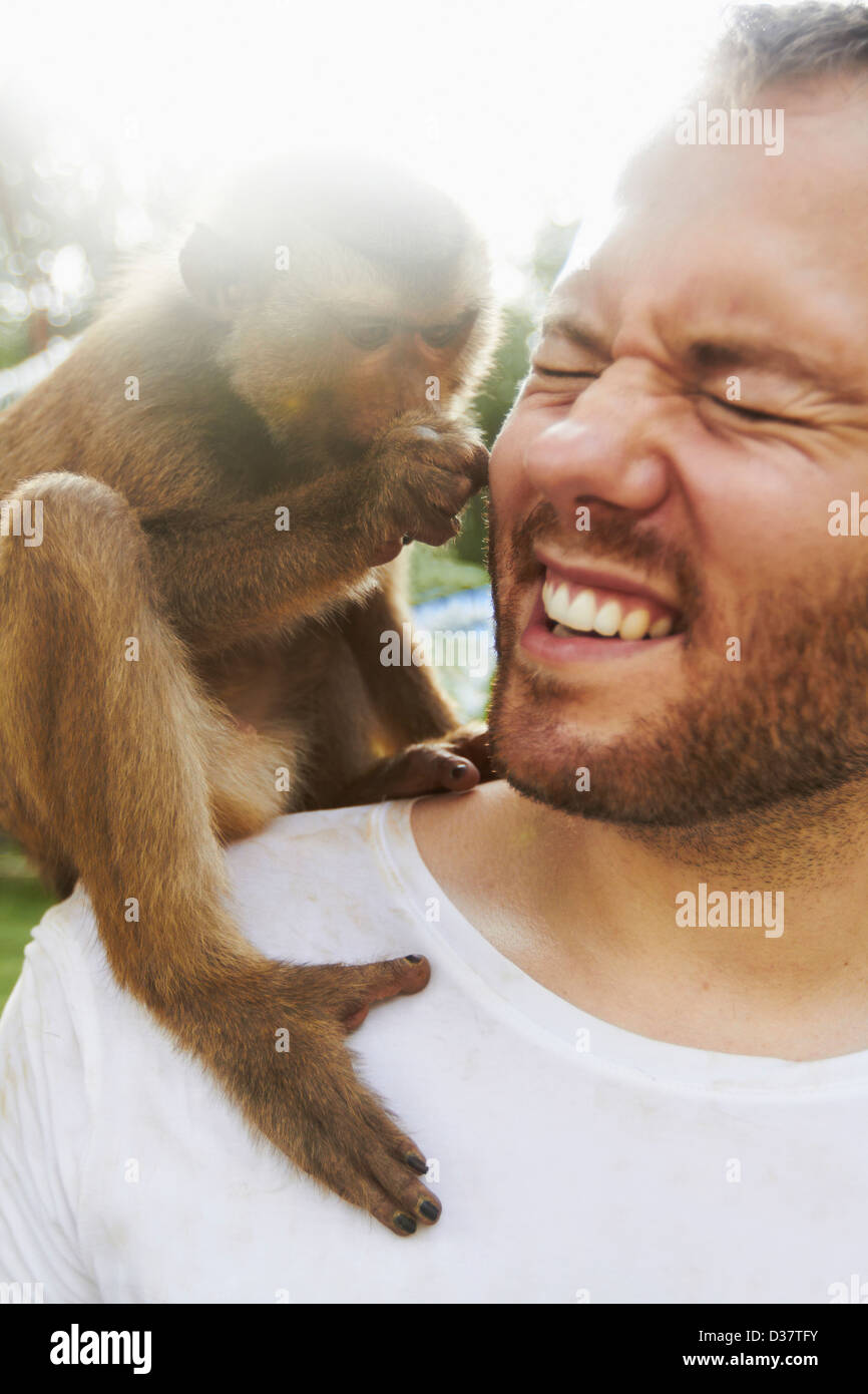 Thailand, Portrait of man holding monkey Stock Photo - Alamy