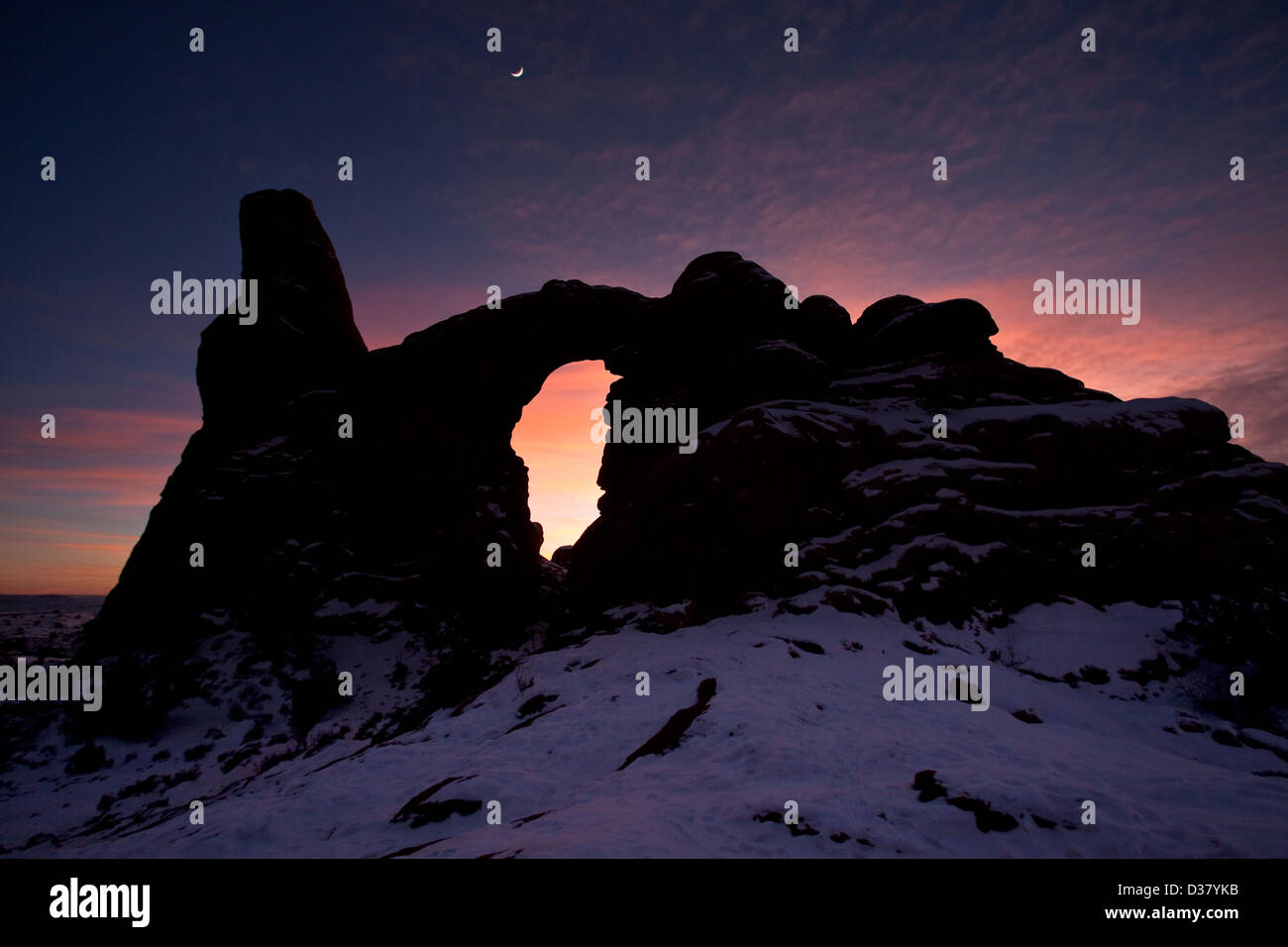 Turret Arch in Arches National Park stands out against a winter sunset ...
