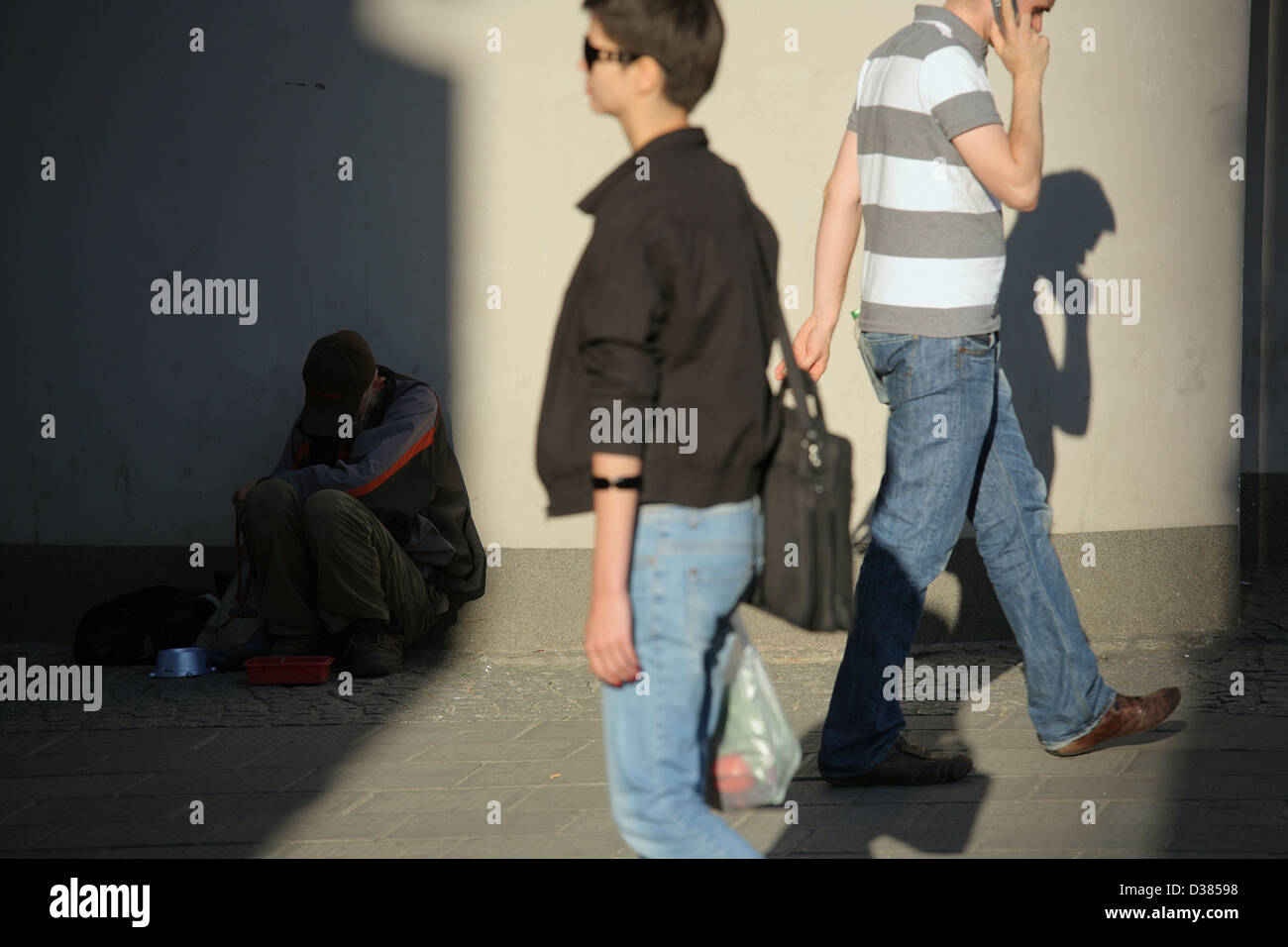 Poznan, Poland, pedestrians walk past a homeless man Stock Photo - Alamy