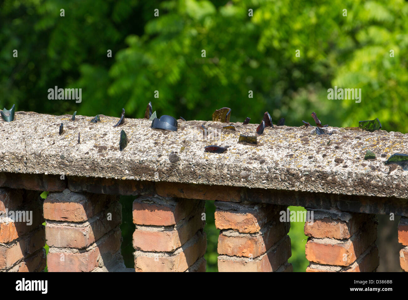 Broken glass cemented into top of fence to act as a security measure ...