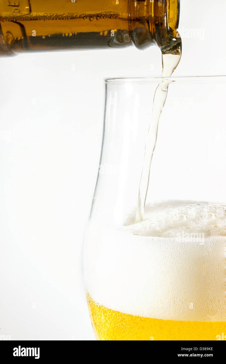 Bottle drops beer into a glass, with great colors Stock Photo - Alamy
