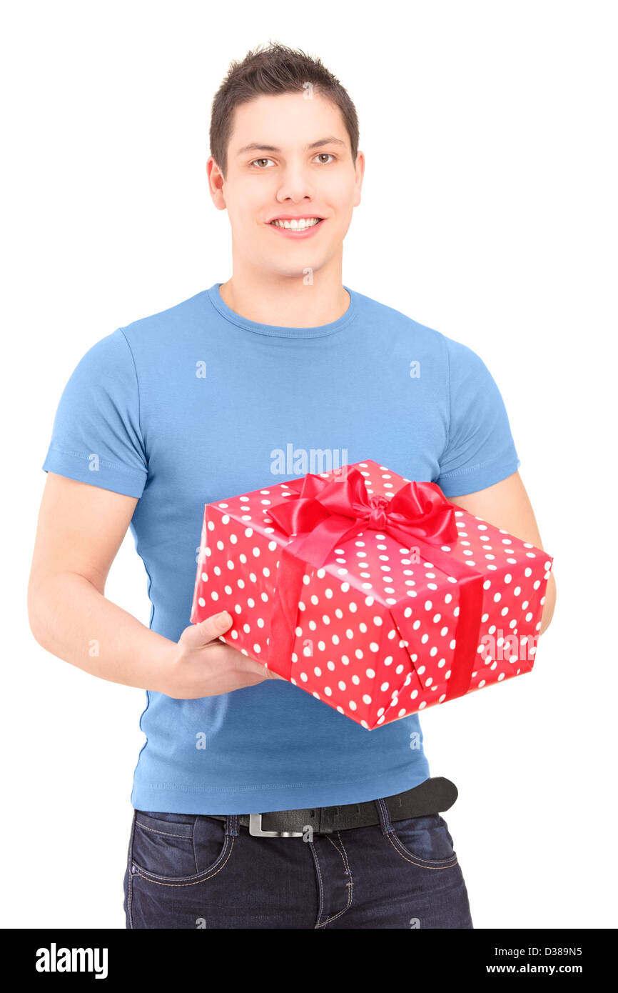 Smiling handsome guy holding a present isolated on white background ...