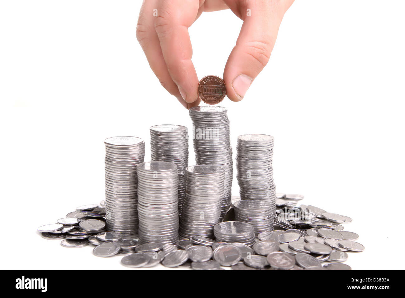 Hand adding coins against white background Stock Photo - Alamy