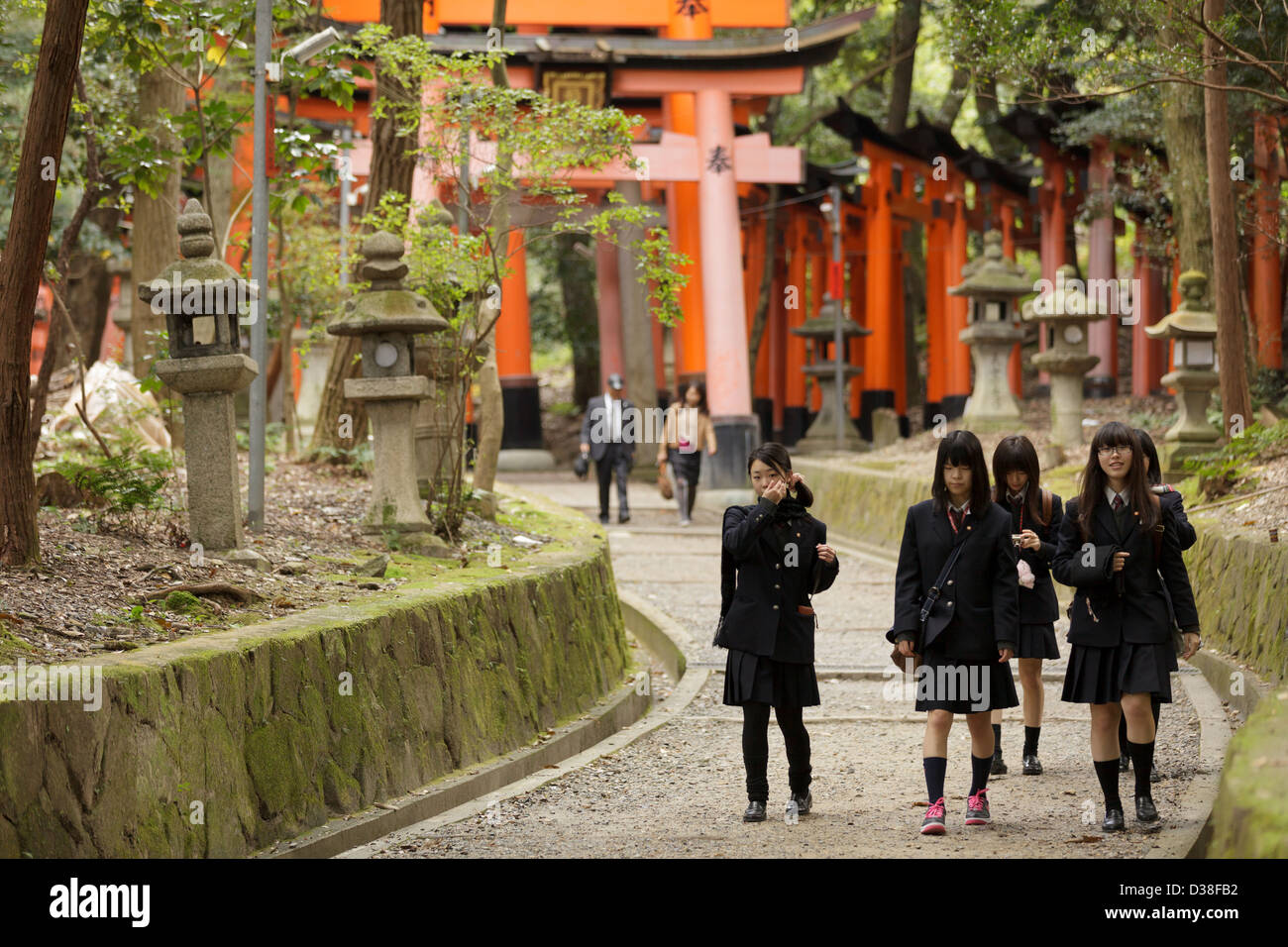 Japanese pupils walking near fushimi Inari shrine torii tunnel in Kyoto ...