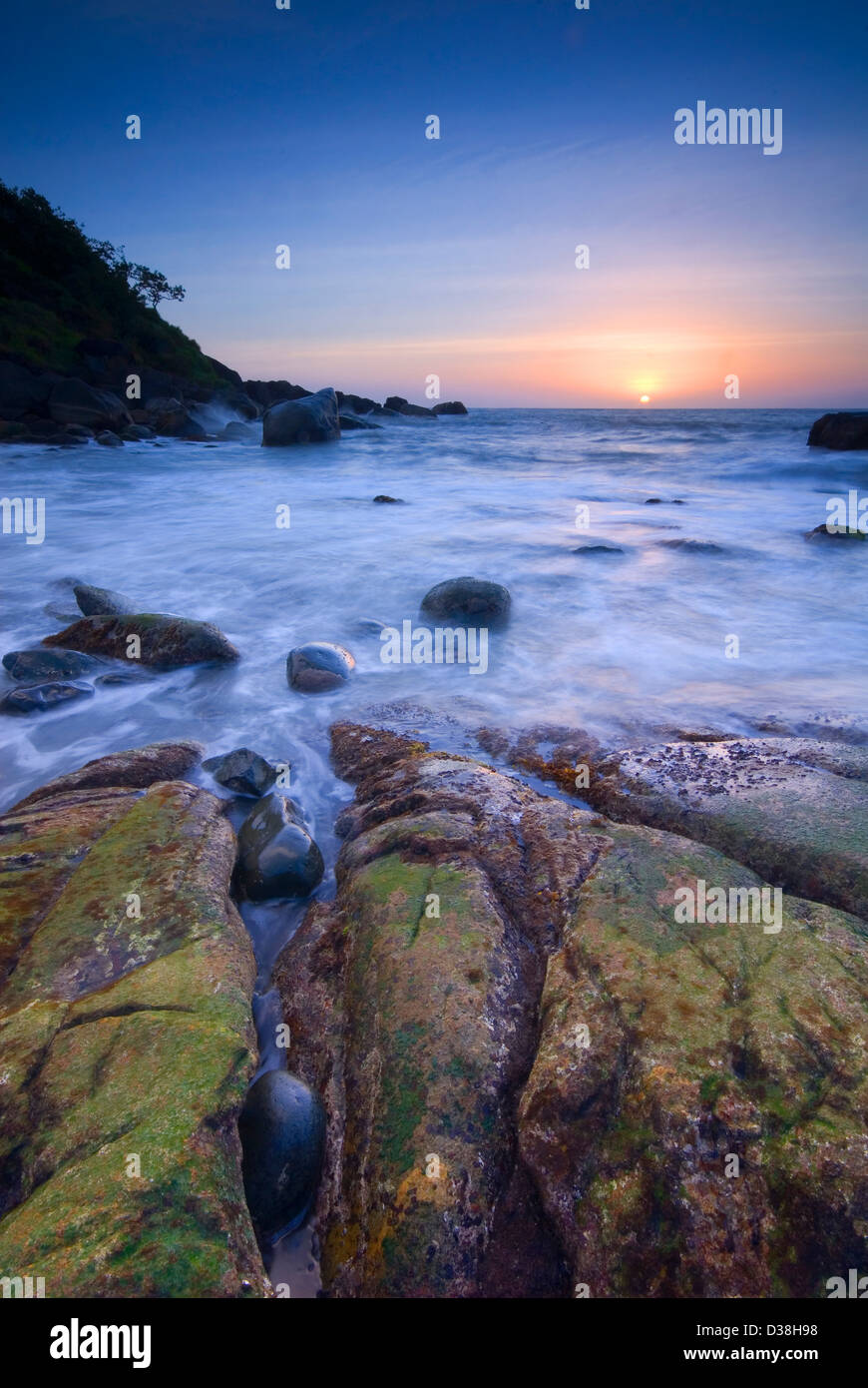 Waves washing over rocks on beach Stock Photo - Alamy