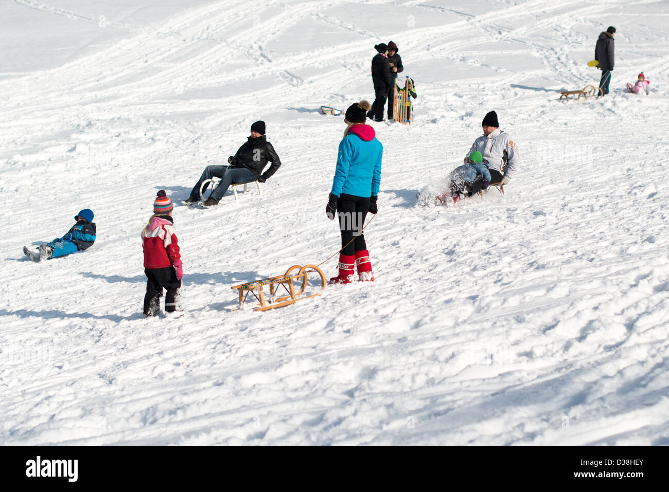 Kids and families having fun with their sledges, bright and white ...