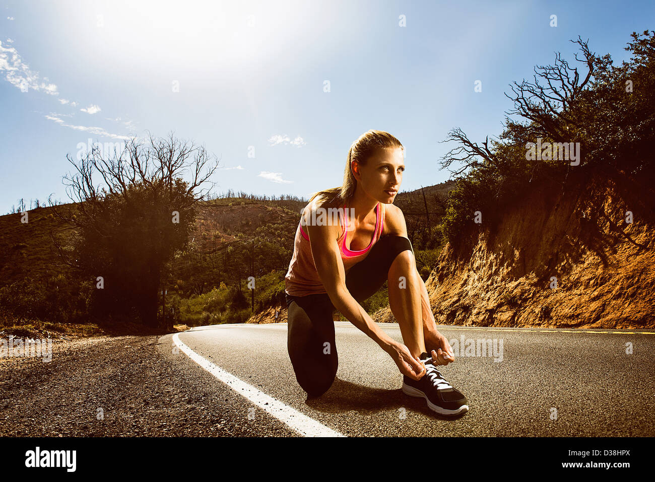 Runner lacing up shoes on rural road Stock Photo - Alamy