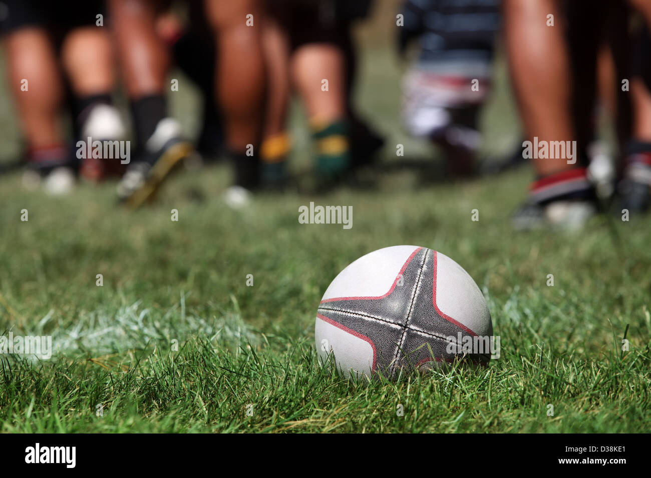 Rugby ball on a grass on a background of legs of players Stock Photo ...