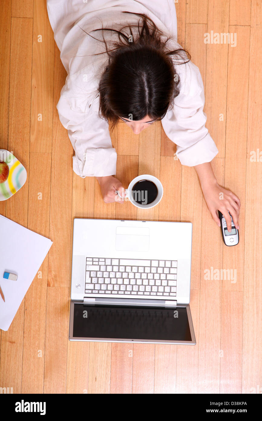 A young adult woman studying on the floor Stock Photo - Alamy