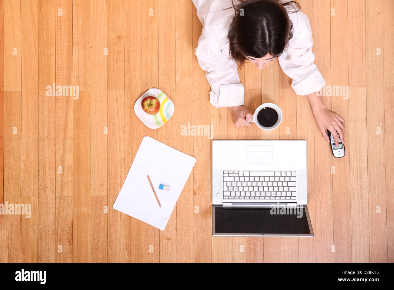 A young adult woman studying on the floor Stock Photo - Alamy