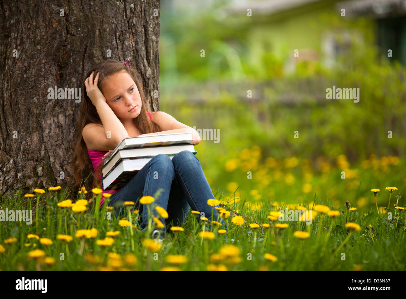 Tired school girl in the park with books Stock Photo - Alamy