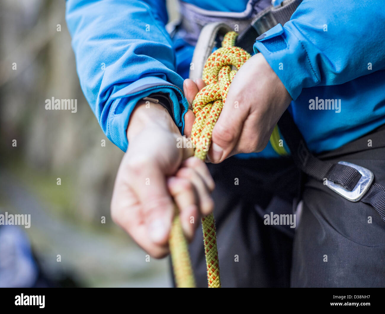 Rock climber tying rope Stock Photo - Alamy