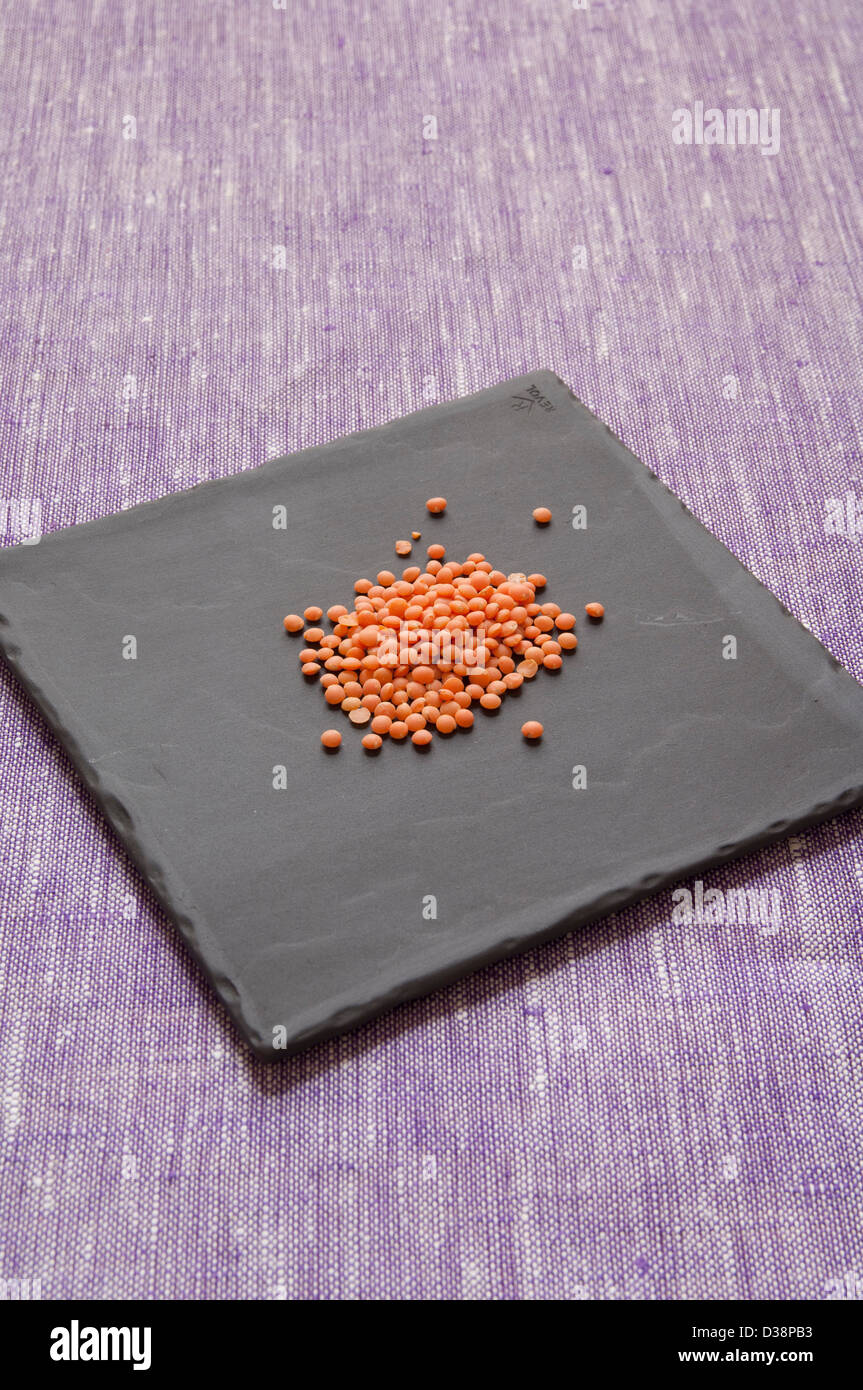 Close-up view of Organic hulled Red small Lentils on a stone plate ...