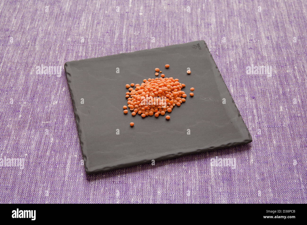 Close-up view of Organic hulled Red small Lentils on a stone plate ...