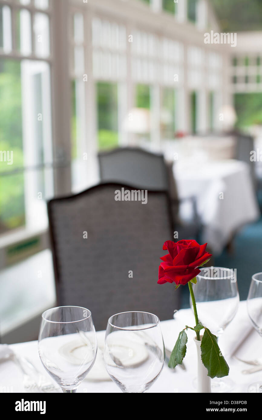 A red rose on a restaurant table set for a romantic meal in an all ...