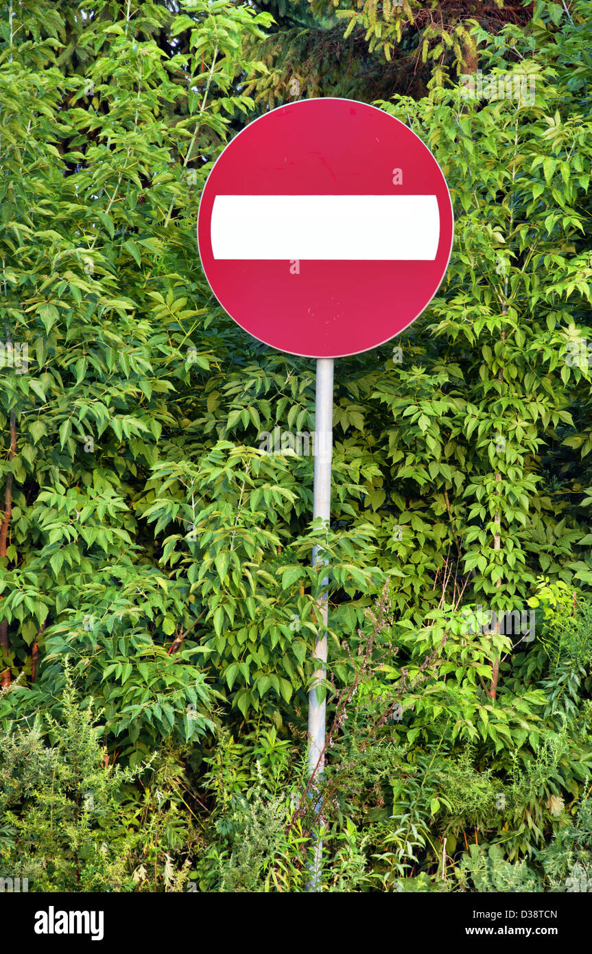 No entry road sign standing in front of the bushes Stock Photo - Alamy