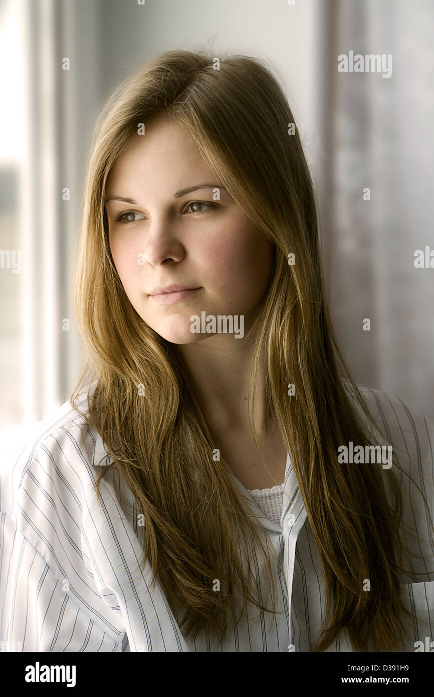 Portrait of a girl in a white shirt in the window Stock Photo - Alamy
