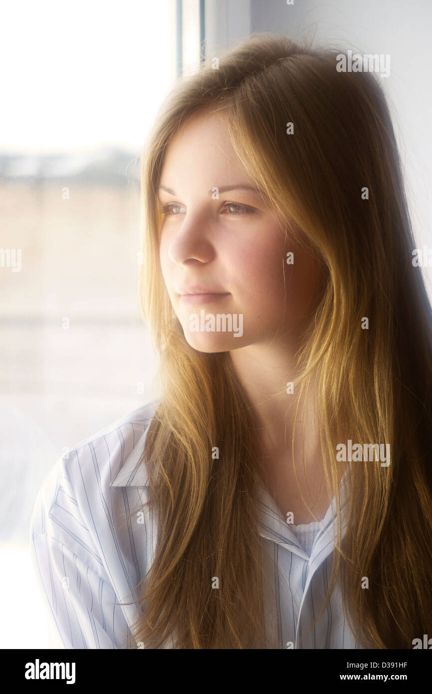 Portrait of a girl in a white shirt in the window Stock Photo - Alamy