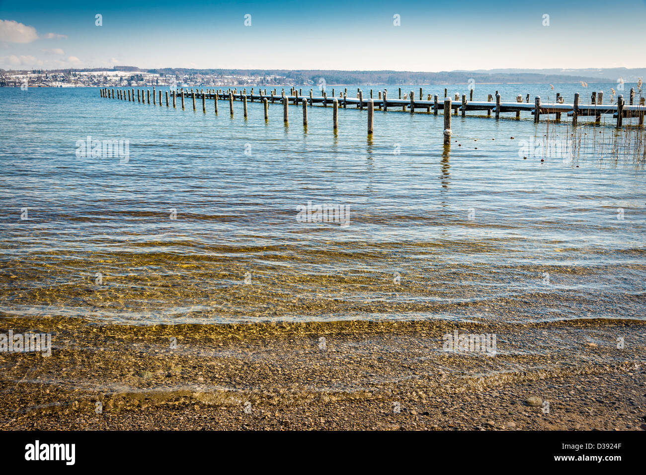 Lake with small waves and landig bridge in the winter with snow and ...