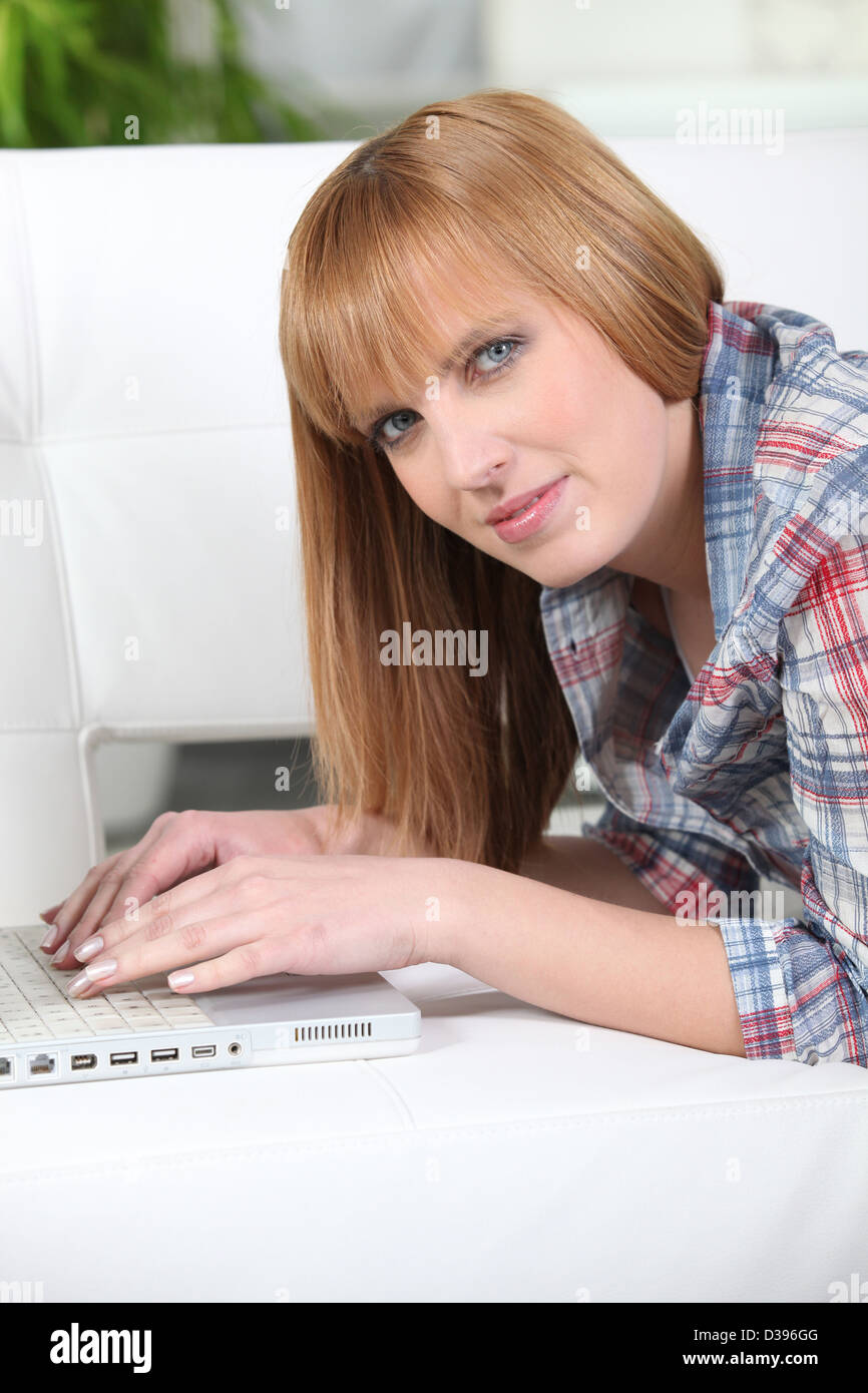 Woman with computer white sofa Stock Photo - Alamy