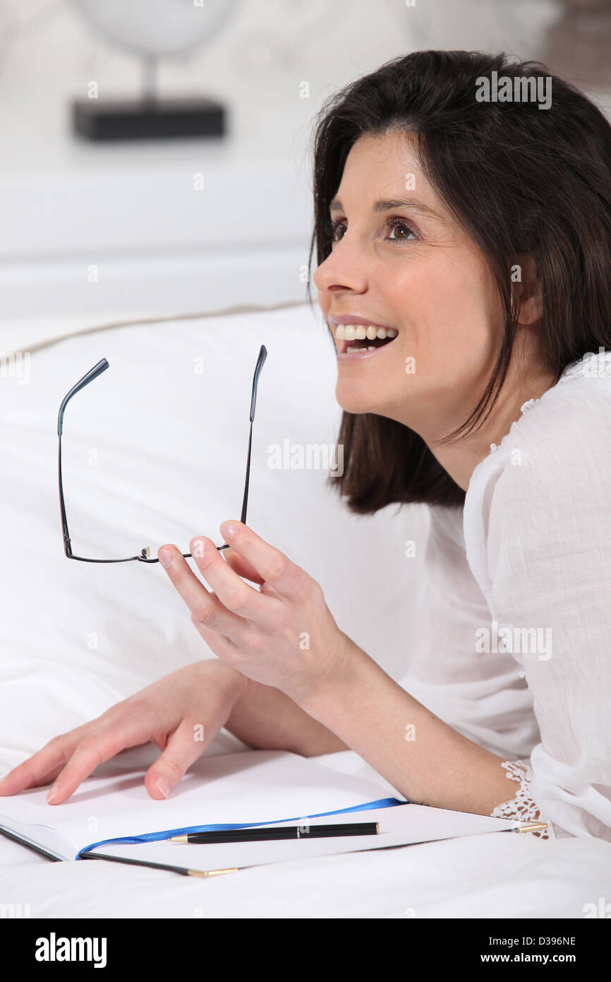 Woman writing in bed Stock Photo - Alamy