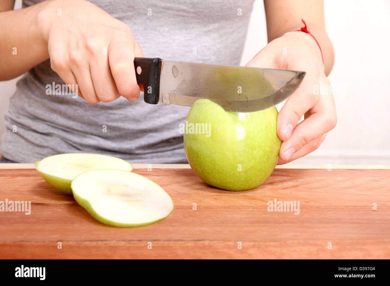 A young adult woman cutting a Apple in the kitchen Stock Photo - Alamy