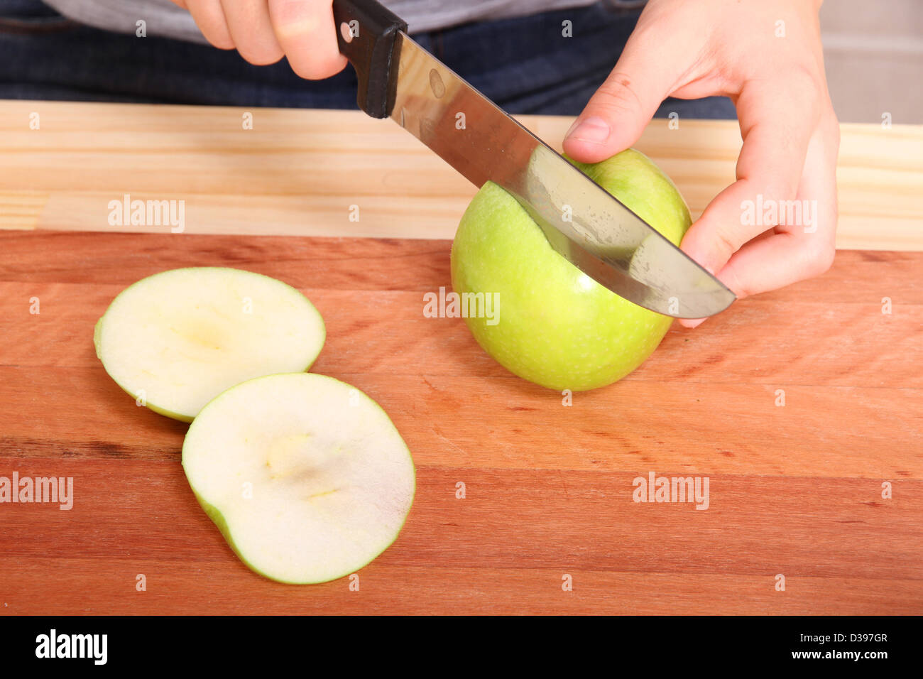 A young adult woman cutting a Apple in the kitchen Stock Photo - Alamy