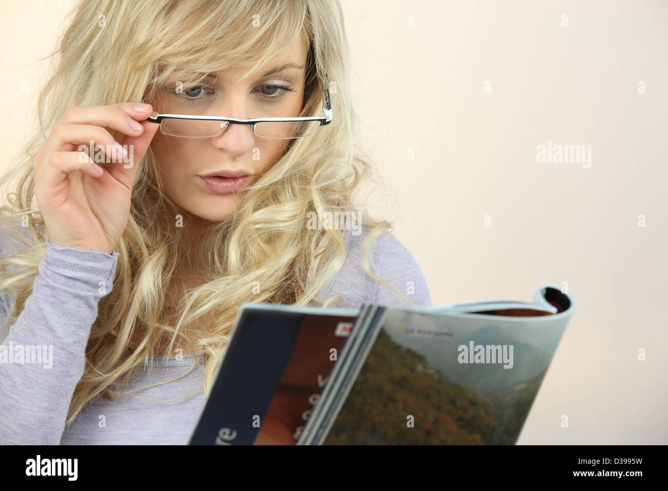 Woman with glasses reading magazine Stock Photo - Alamy