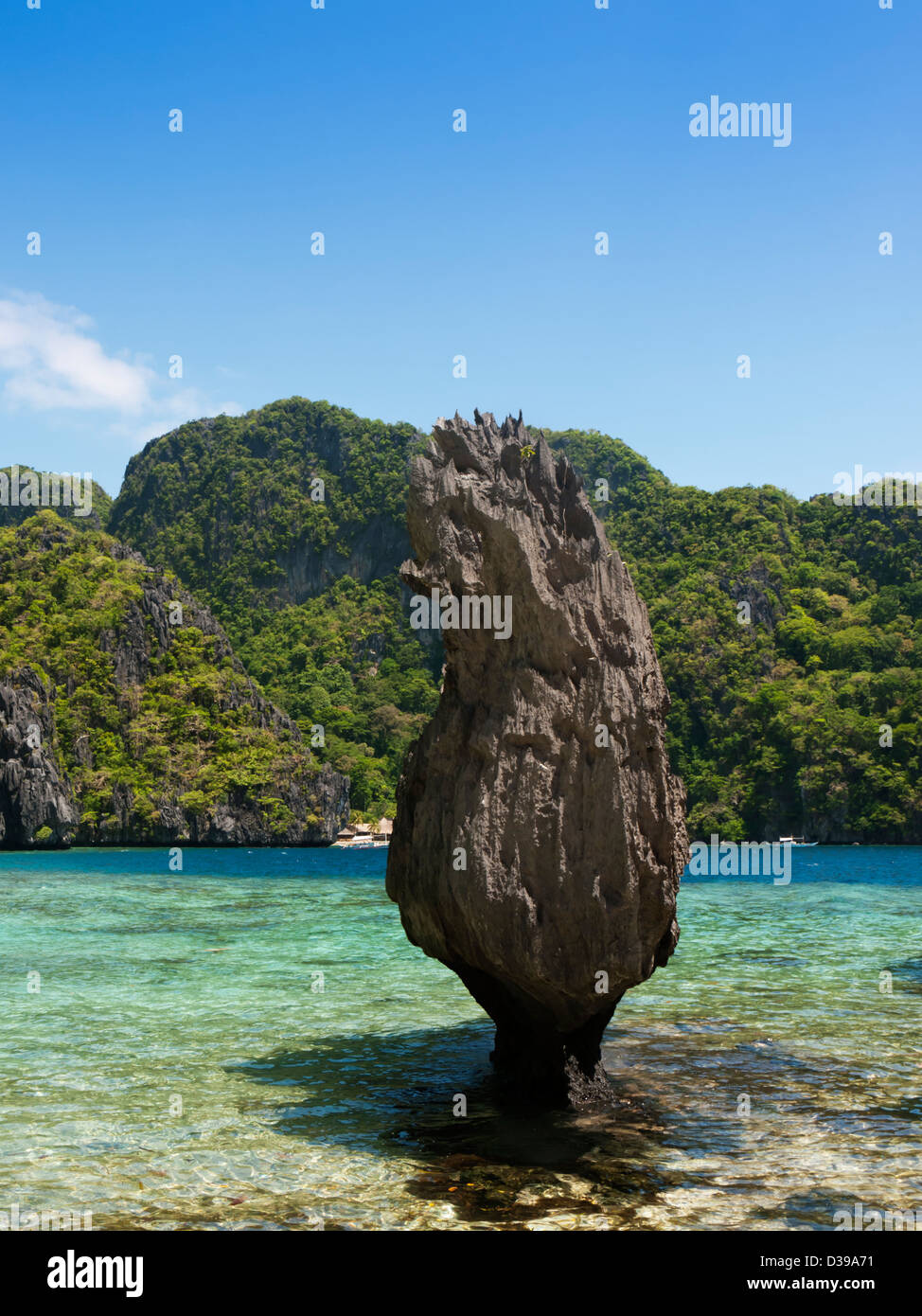 Karst rock formation standing in clear sea lagoon, El Nido, Philippines ...