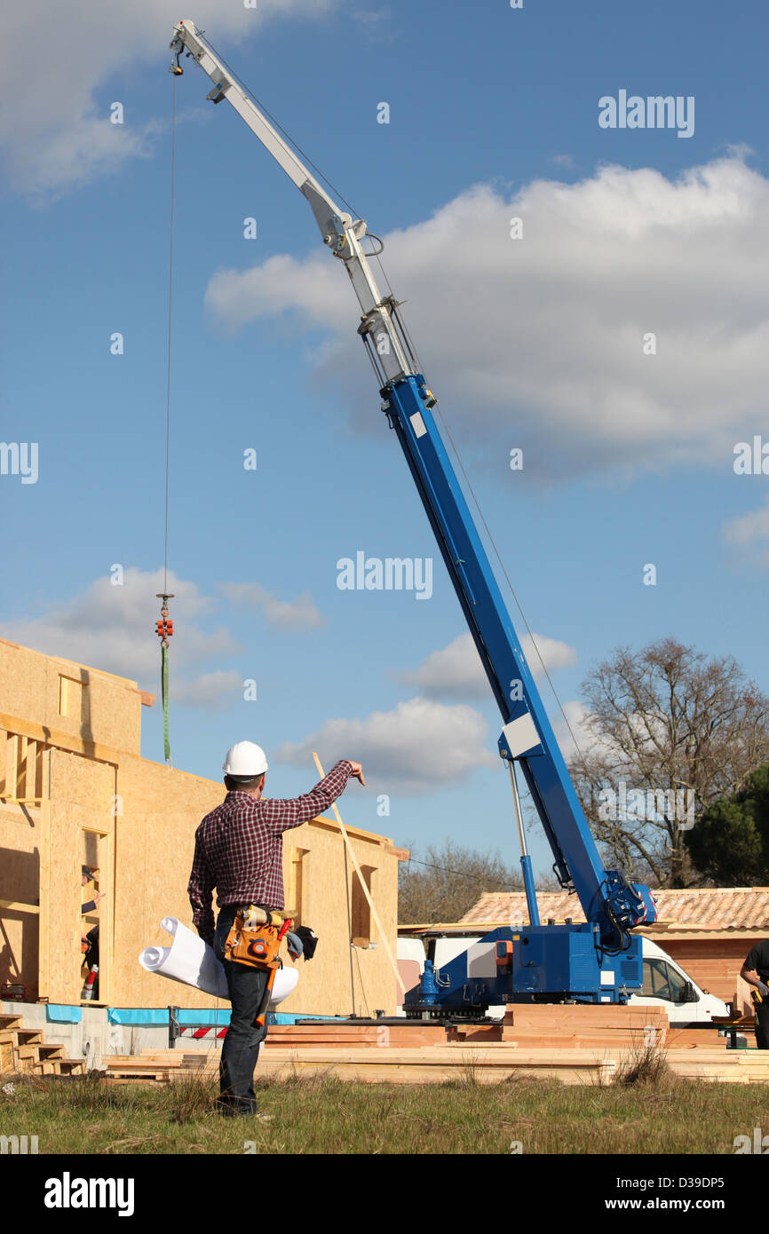 Construction worker on site with a crane Stock Photo - Alamy