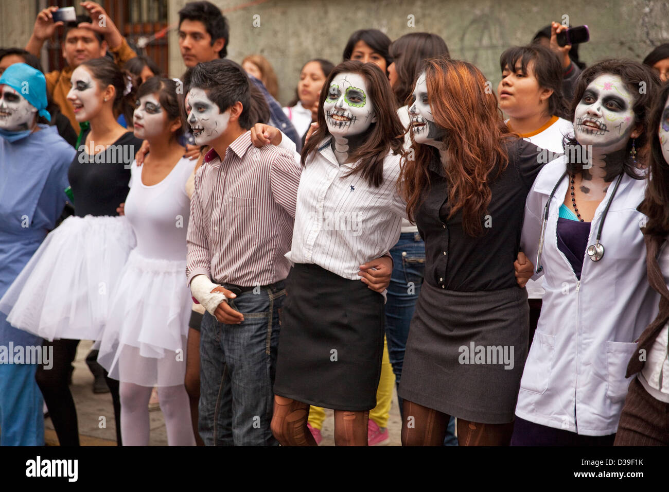 Young people with painted faces smiling and watching Day of the Dead ...