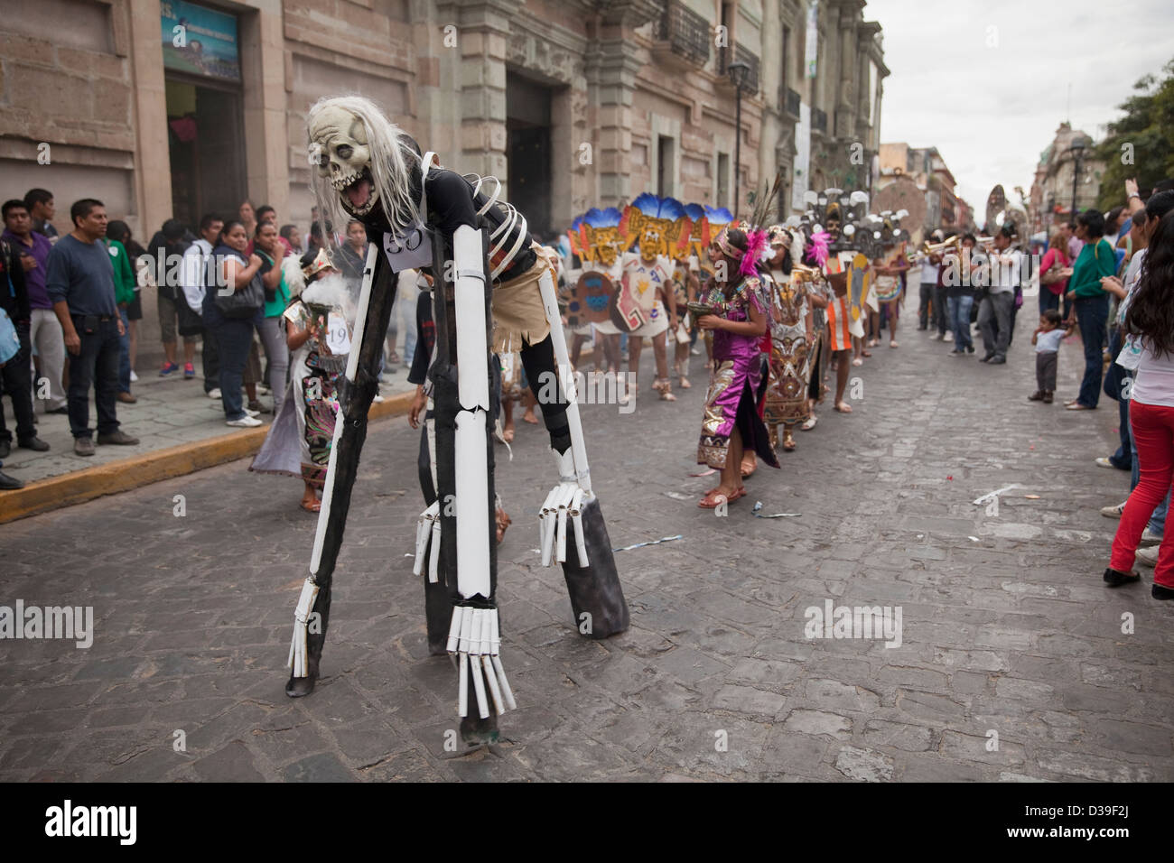 Person in skeleton costume on stilts, other costumed participants, and ...
